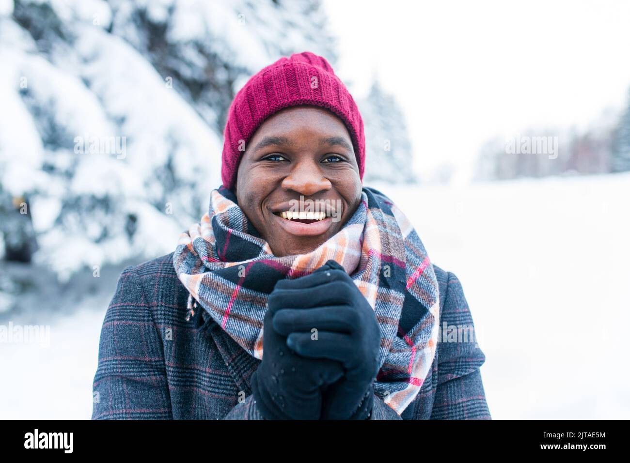 african american handsom man in red hat and stylish plaid coat look at ...