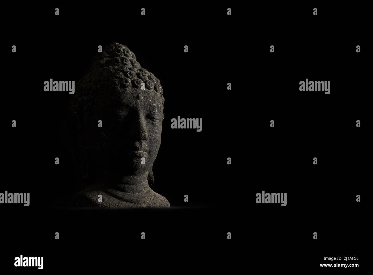 Head of Buddha statue with dramatic low key lighting Stock Photo - Alamy