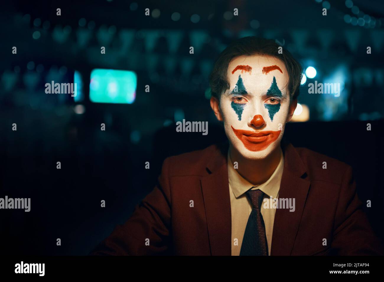 Guy in suit and tie with the Joker makeup looks at the camera Stock ...