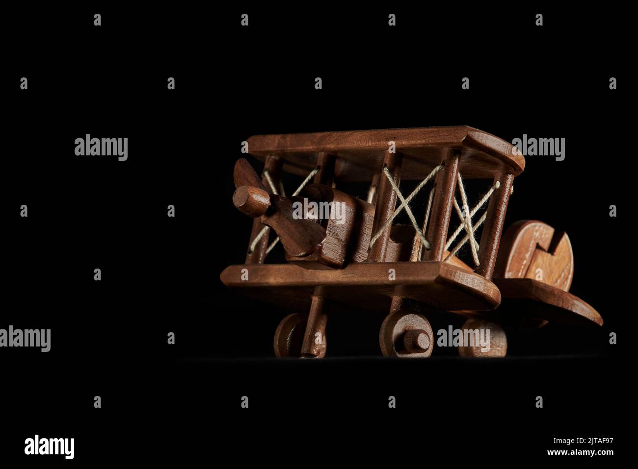 Classic wooden airplane toy with low key lighting Stock Photo - Alamy