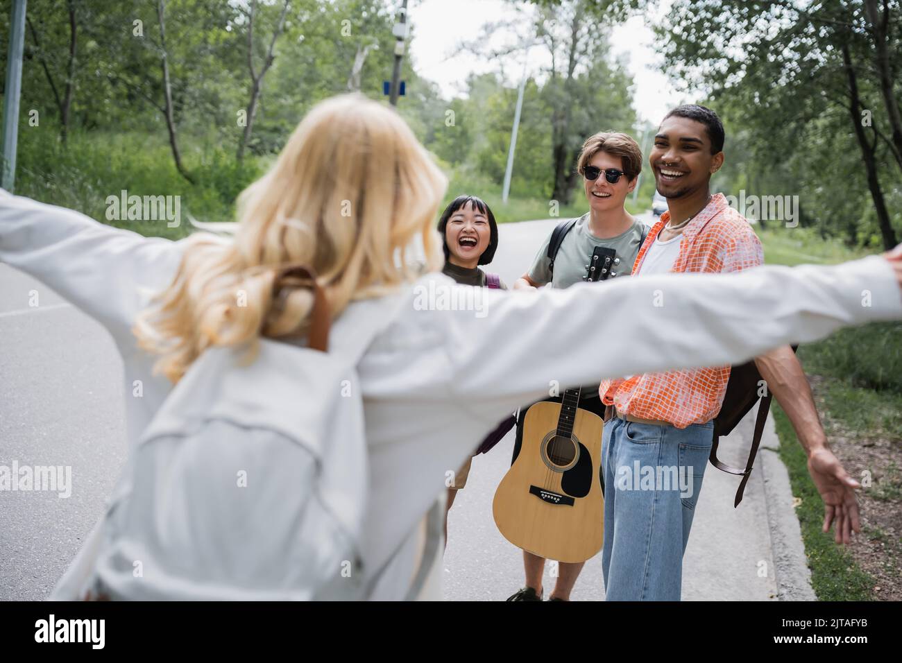 blurred woman with outstretched hands running towards happy multiethnic ...