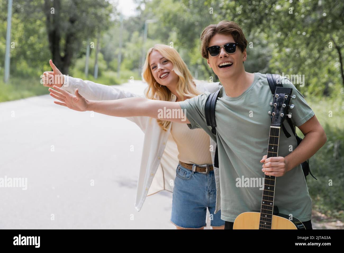 young and happy hitchhikers stopping car on countryside road Stock ...