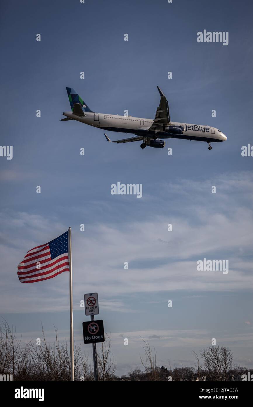 A low angle view of a Jet blue plane in flight landing over an American ...