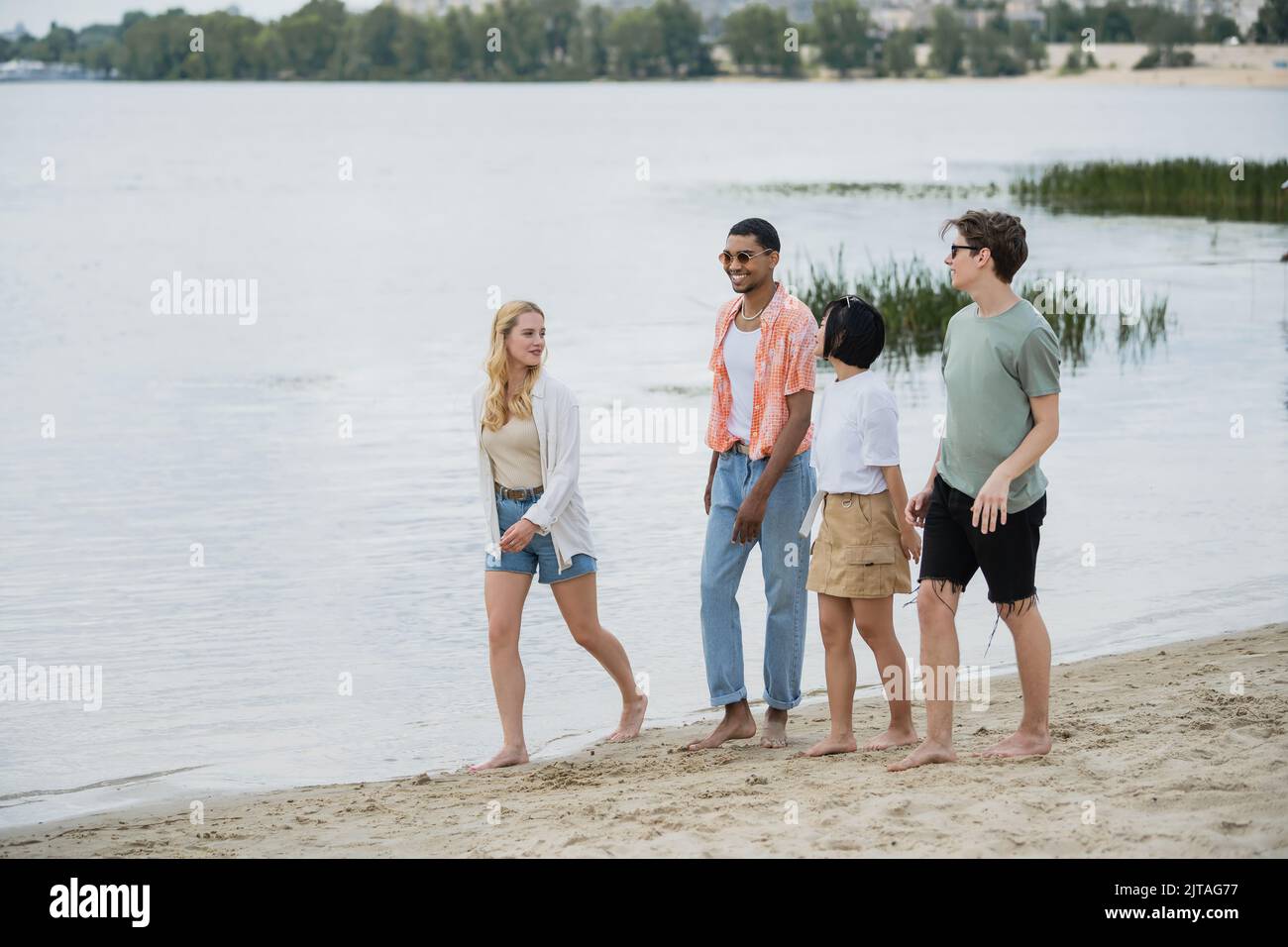 Full Length Of Young And Happy Multiethnic Friends Walking On Summer