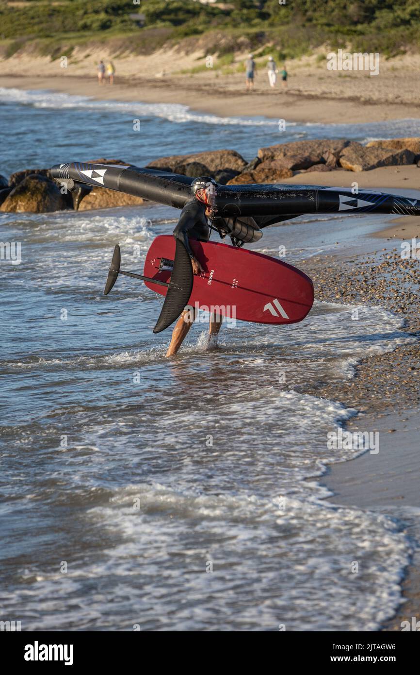 A wing foiler enjoying riding above the waves on a windy day in New ...