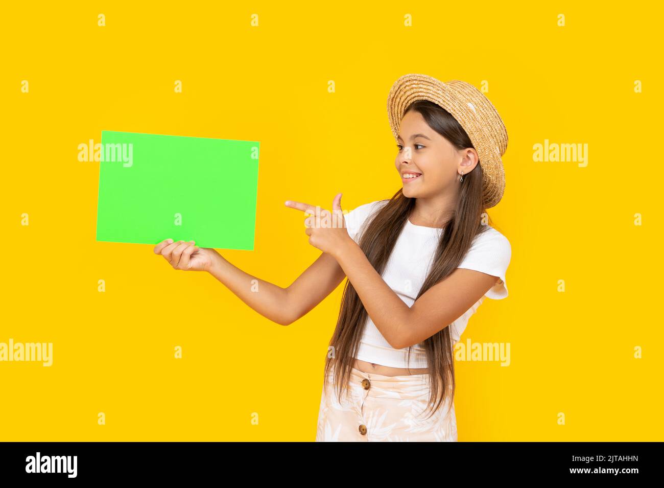 happy teen girl with copy space on green paper on yellow background ...