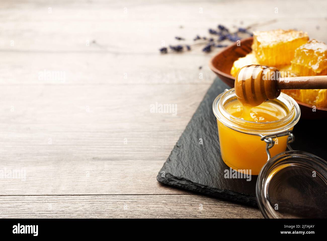 Honey on wooden honey-dipper closeup food background with copy-space ...