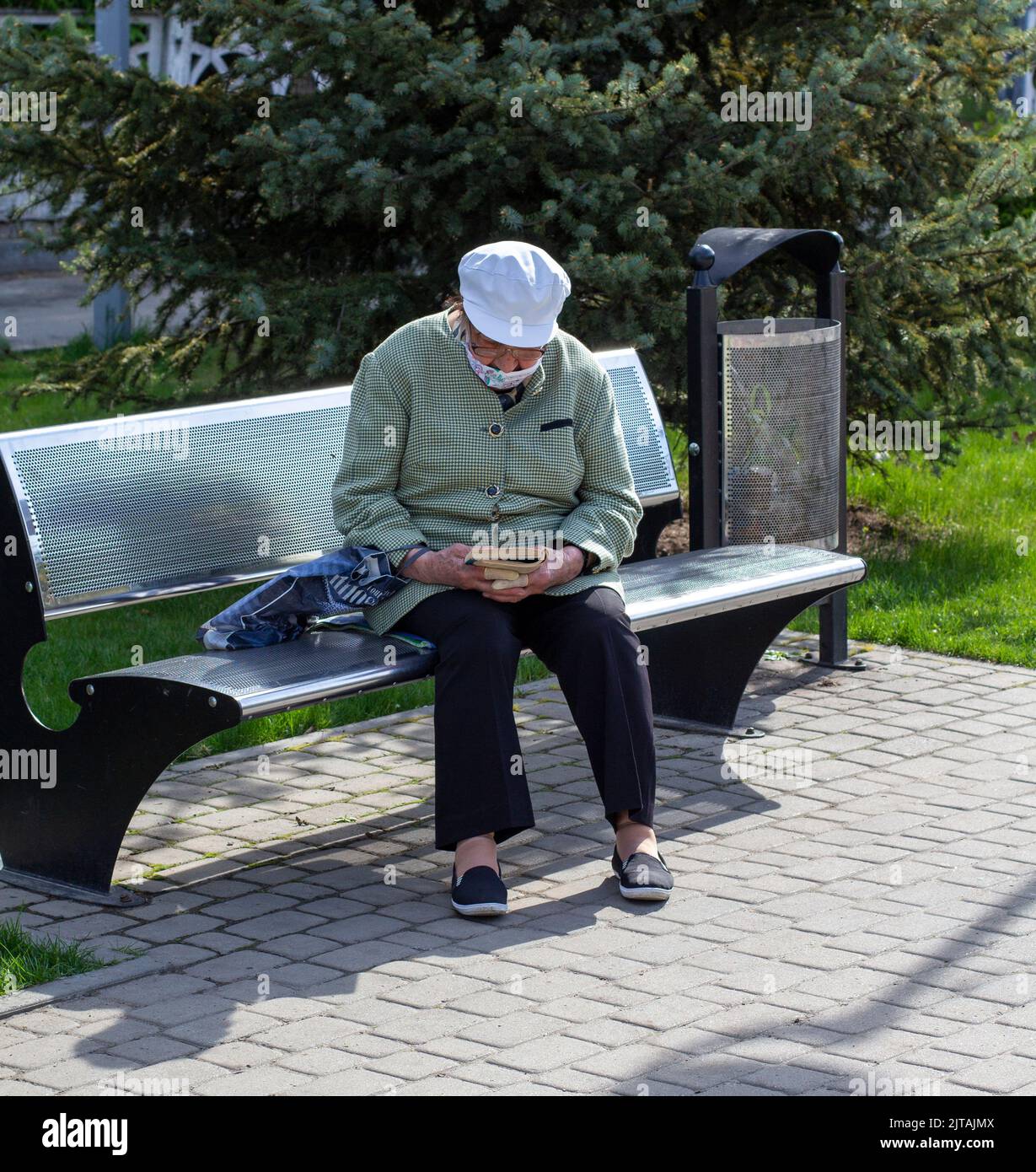 Novomoskovsk, Ukraine - May 13, 2021: elderly woman in mask on bench on ...