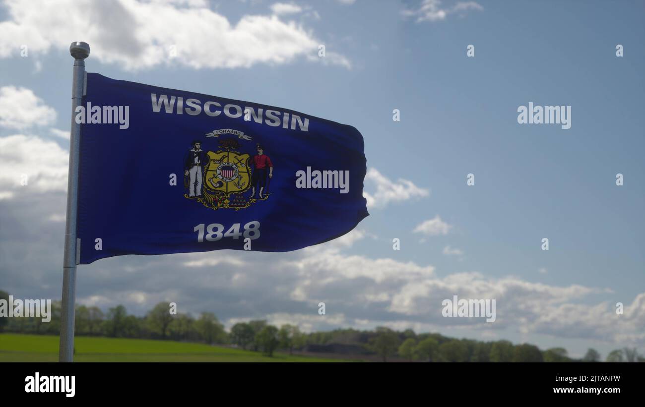 Wisconsin flag on a flagpole waving in the wind, blue sky background ...