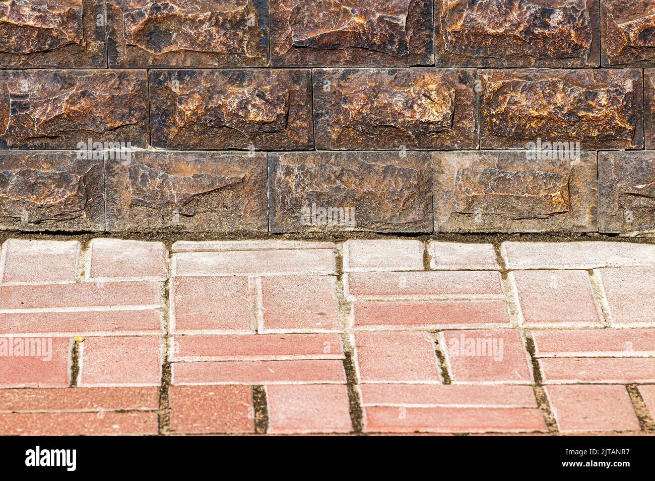 Texture of a wall covered with decorative brick-like tiles and pavement ...