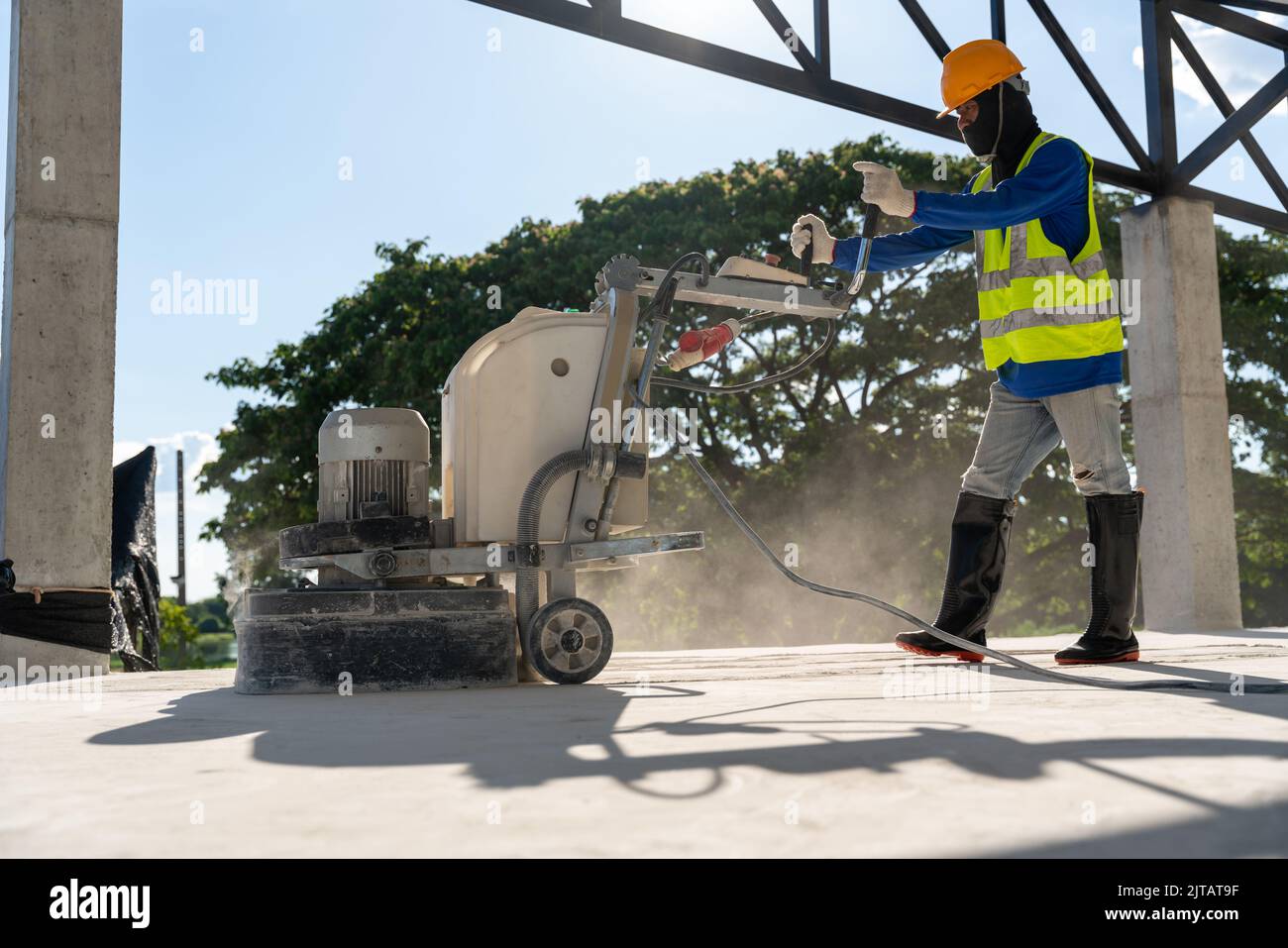 A man wear safety works with grinding machine for concrete floor at ...