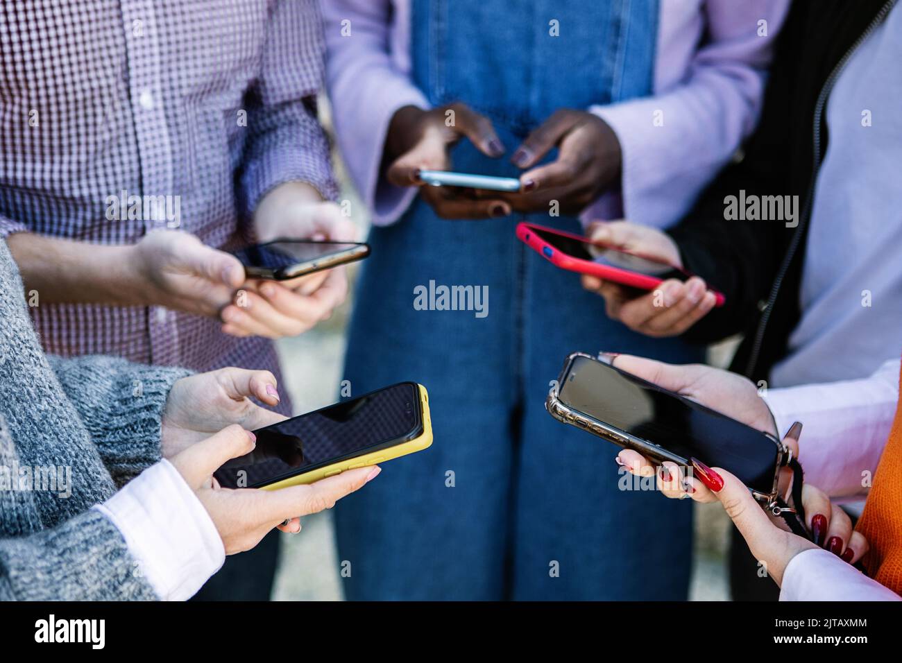 Close up young people hands using mobile phone together Stock Photo - Alamy