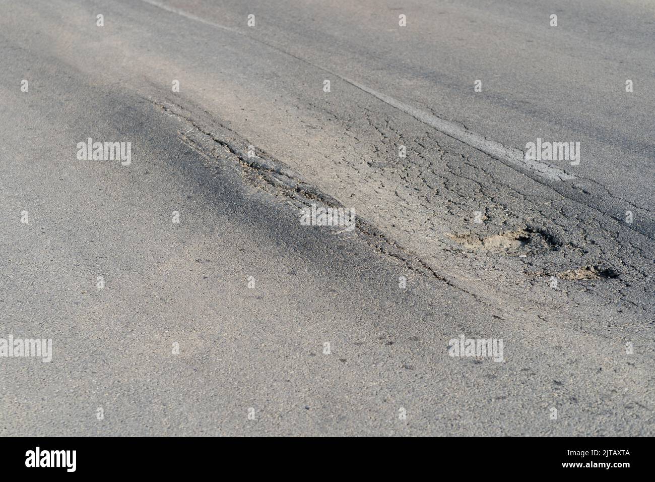 Deformed asphalt surface with potholes caused by heavy overloaded ...