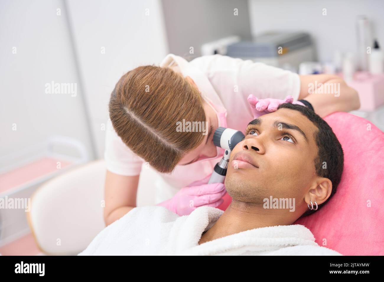 Professional dermatologist performing dermatoscopy on male patient ...