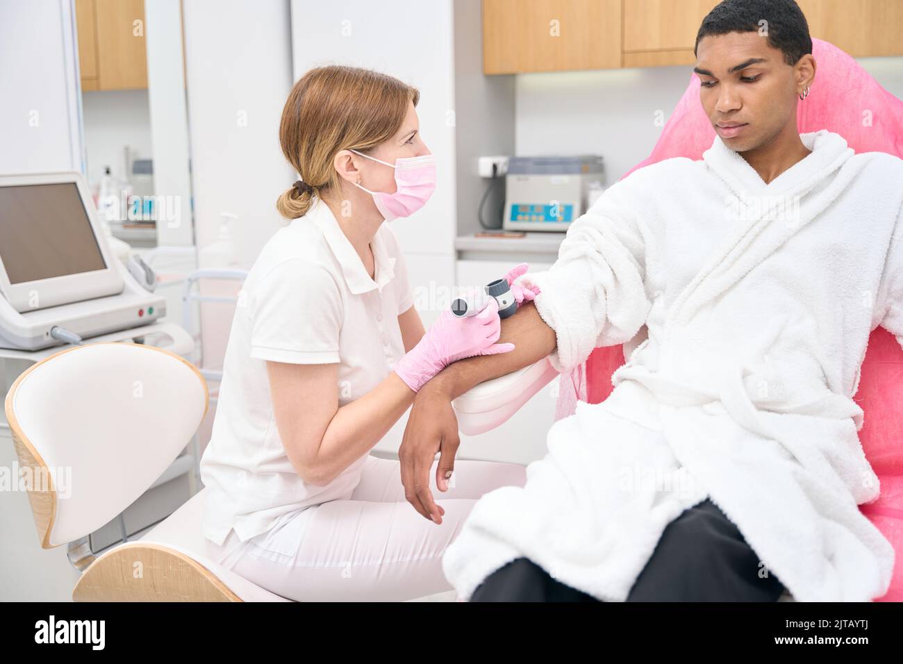 Professional dermatologist examining male patient skin with ...