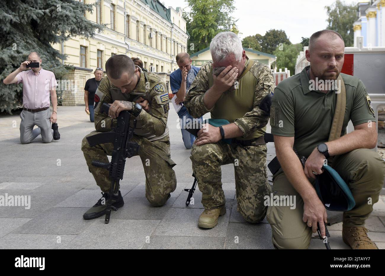 KYIV, UKRAINE - AUGUST 28, 2022 - Servicemen kneel to show their ...