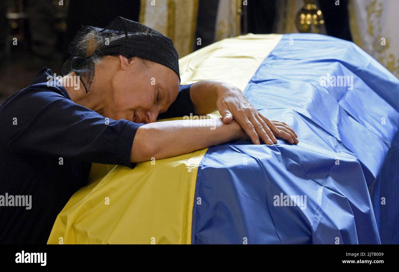 KYIV, UKRAINE - AUGUST 28, 2022 - A woman in black mourns by the coffin ...