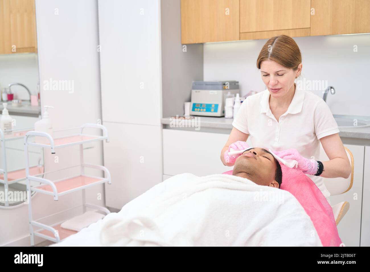 Aesthetic clinic doctor preparing young person for cosmetic procedure ...