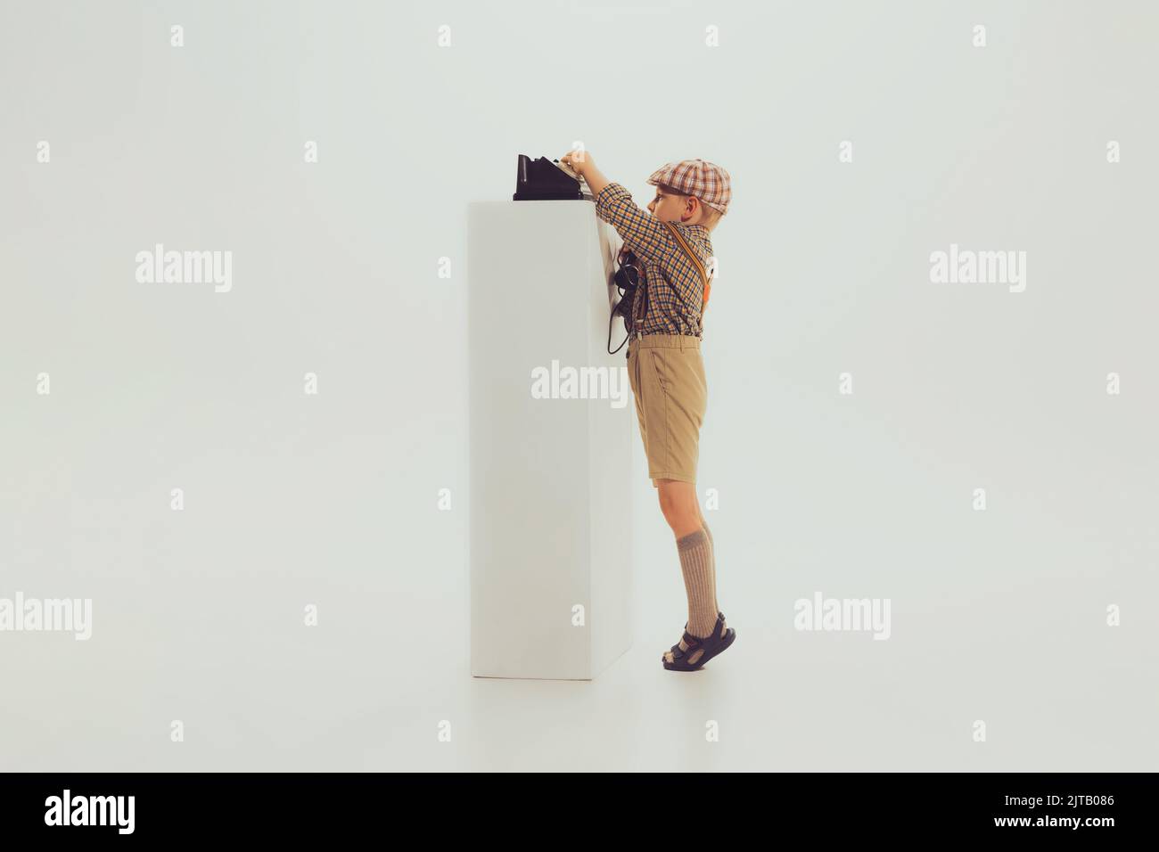 Portrait of little boy, child standing on tiptoe, trying to reach ...