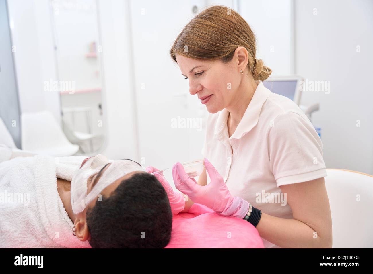 Cosmetician performing cosmetic procedure on man skin Stock Photo - Alamy
