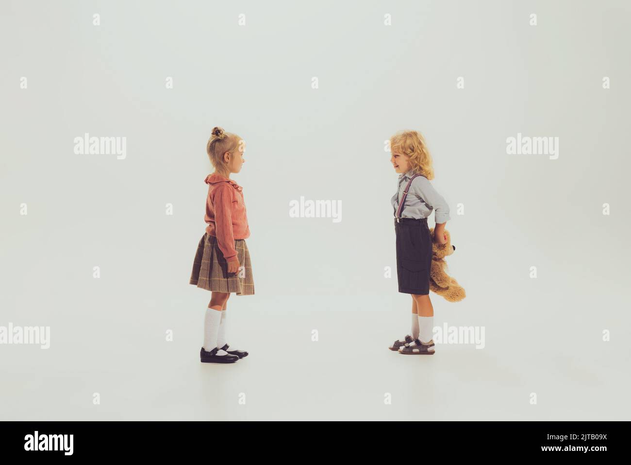 Portrait of two stylish kids posing isolated over grey studio ...
