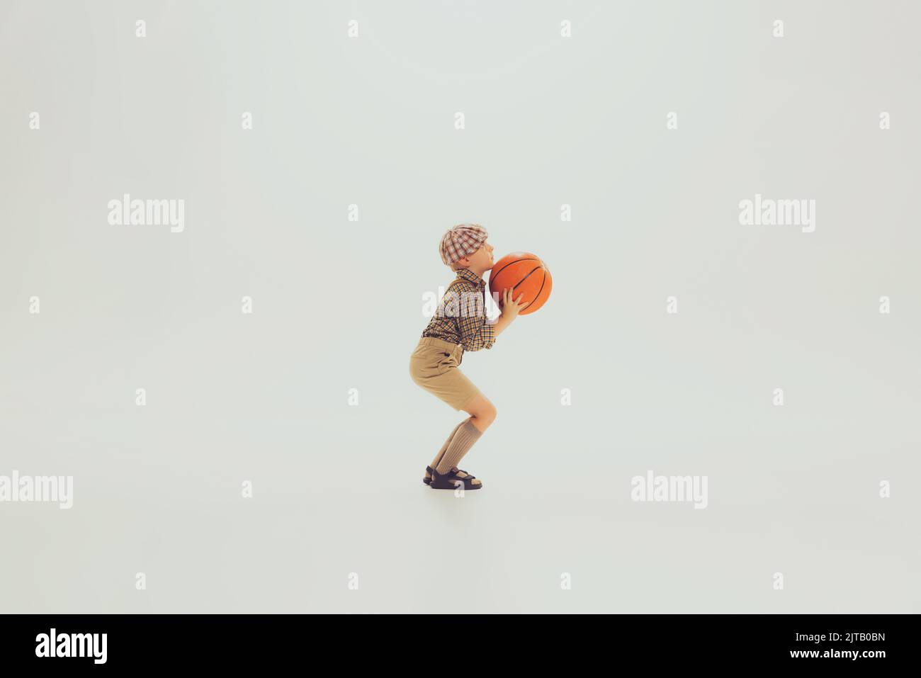 Portrait of little boy, child in checkered shirt playing basketball ...