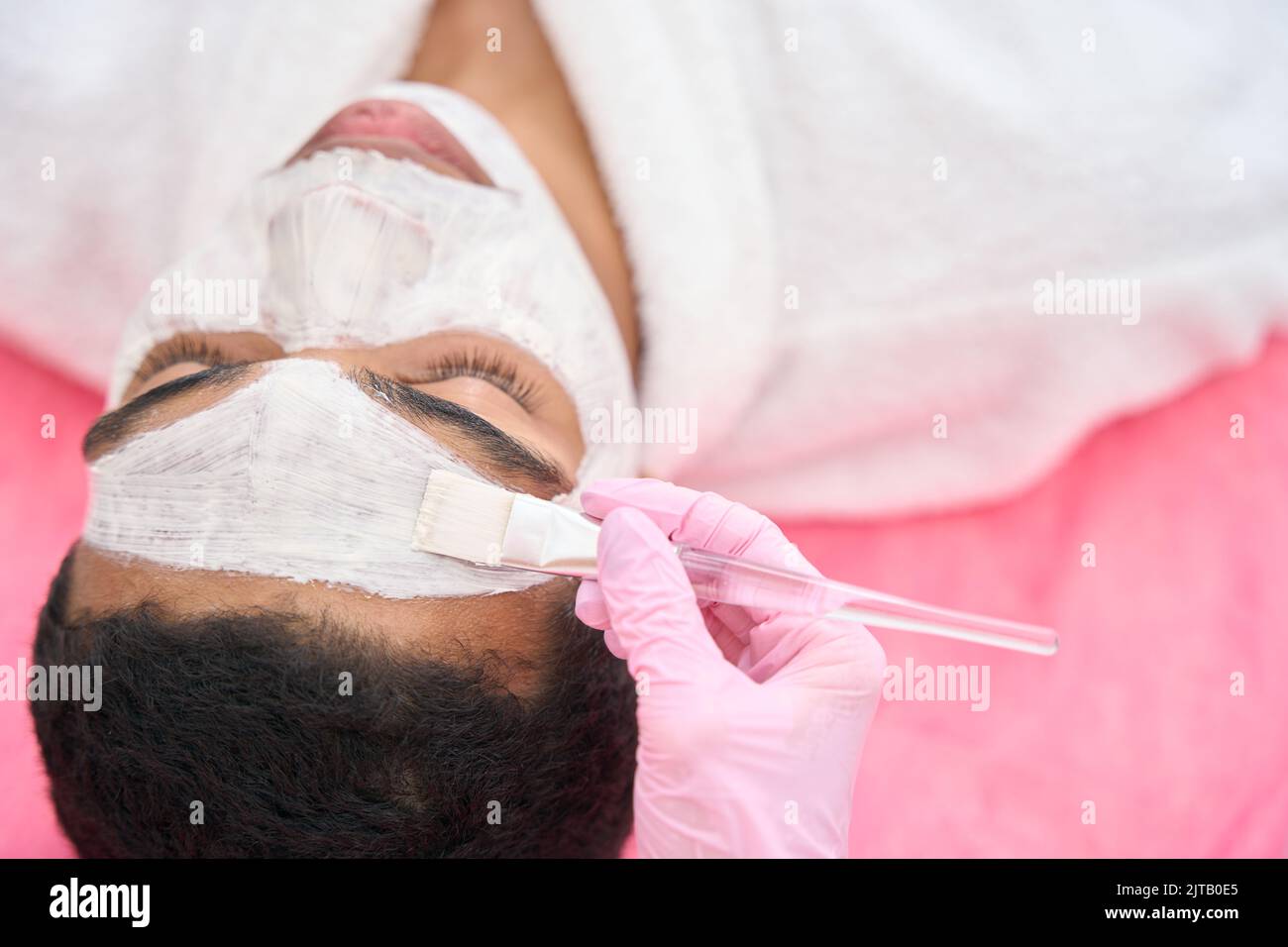 Esthetician applying mask to young man skin Stock Photo - Alamy