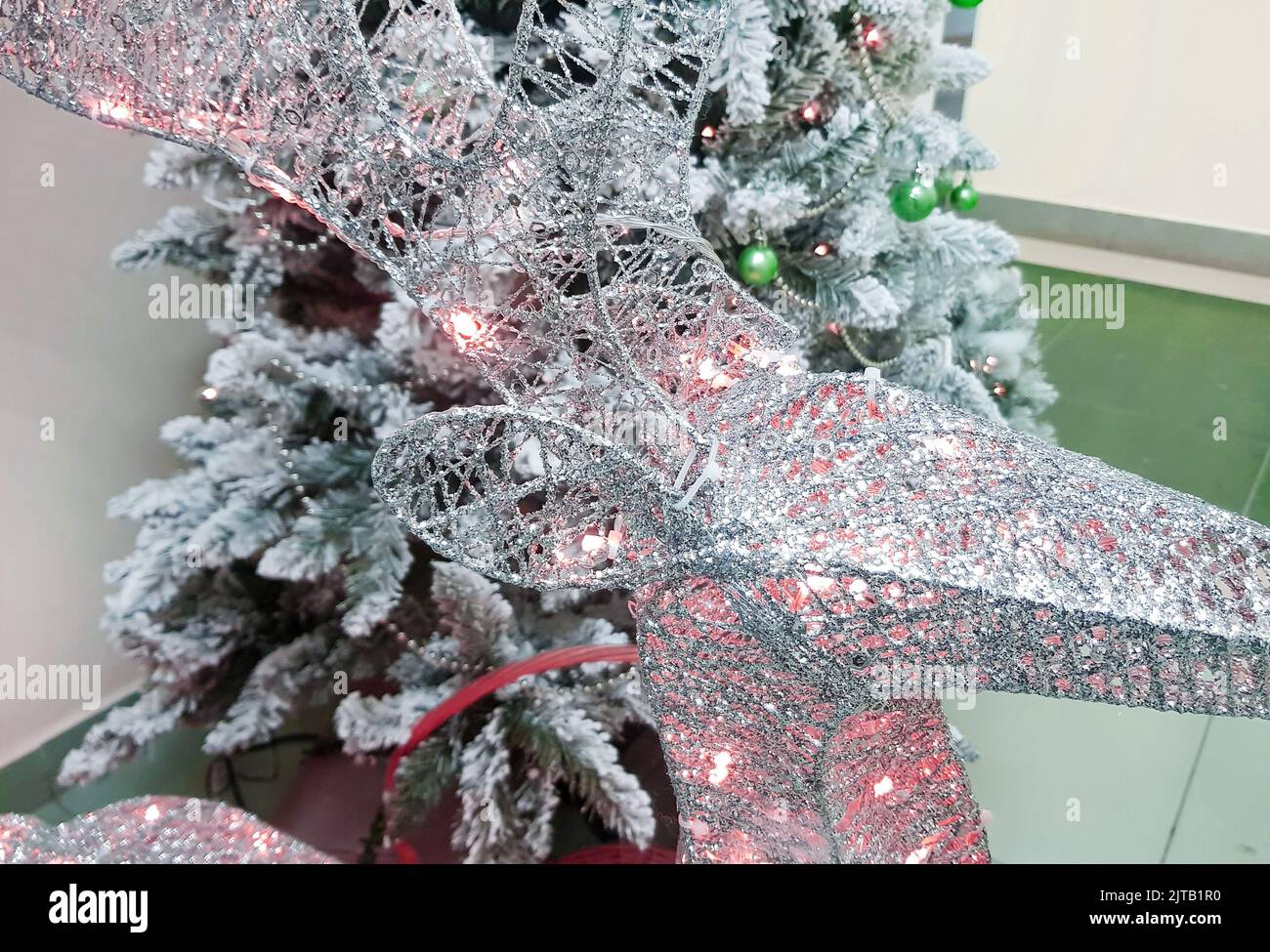 Close-up of a braided deer head on a Christmas tree background. The ...