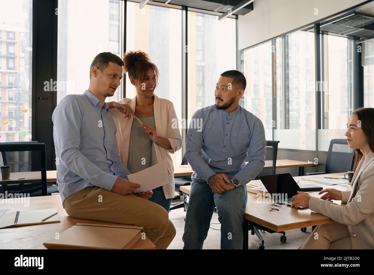 Joyful colleagues communicate with each other in the office Stock Photo ...
