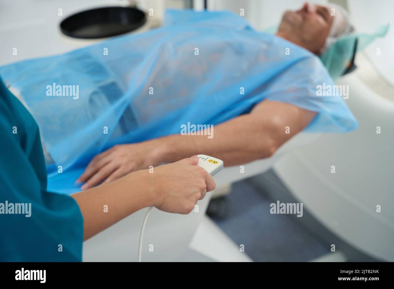 Patient on tomography, control panel in nurse's hands Stock Photo - Alamy