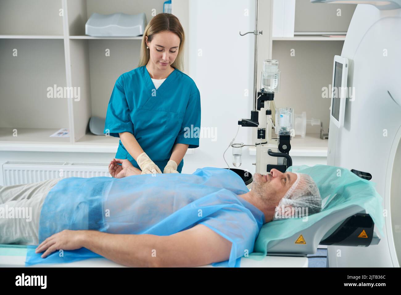 Nurse injecting medicinal substance into patient's hand in medical ...