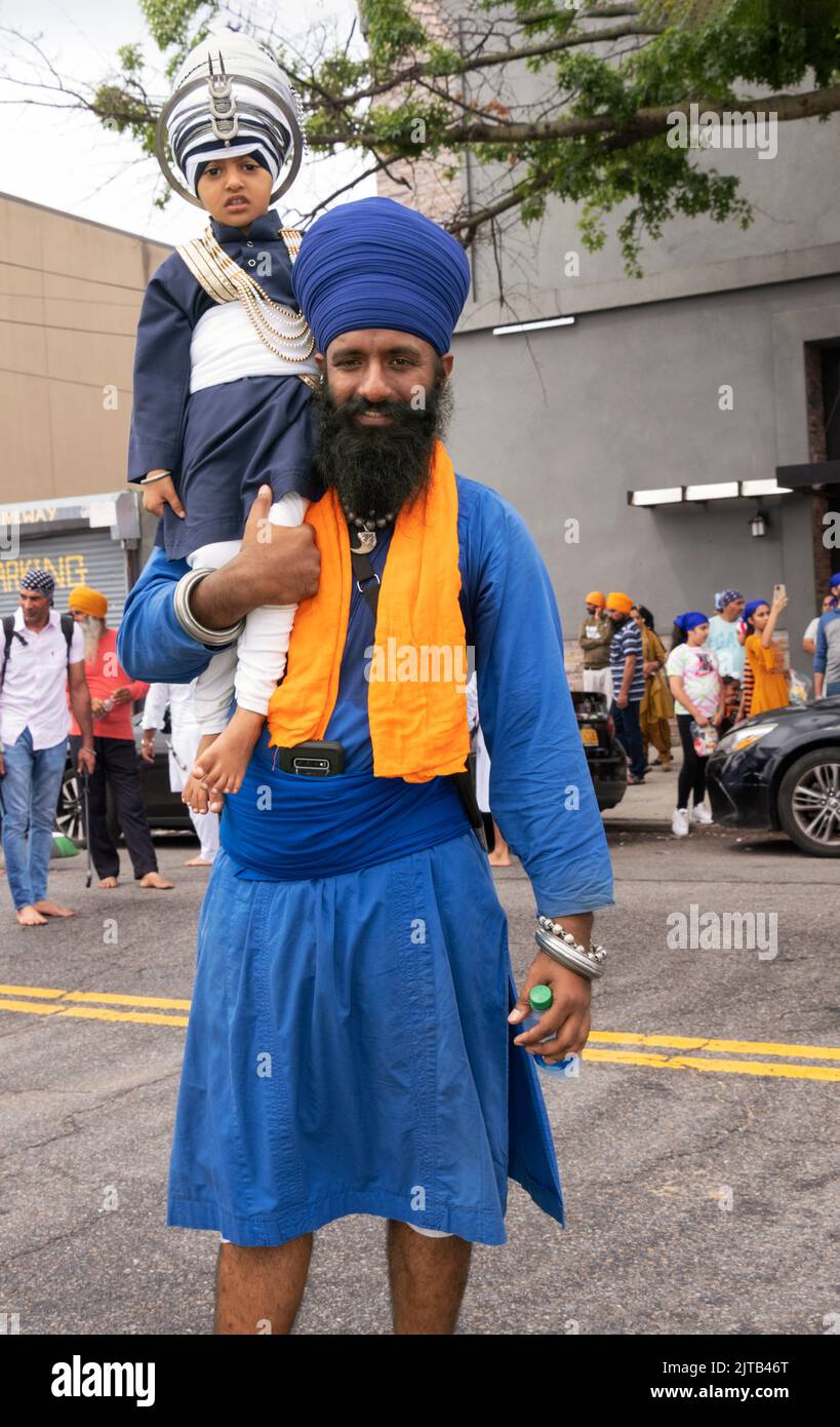A Sikh father dressed in blue, carries his cute daughter during the ...