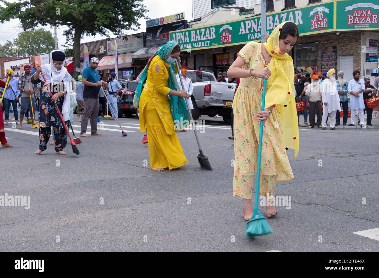 Devout Sikh women and men sweep 101st Avenue where a parade float carry ...
