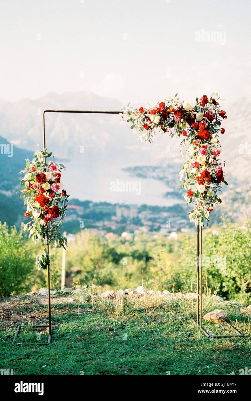 Metal wedding arch decorated with flowers on top of a mountain above ...