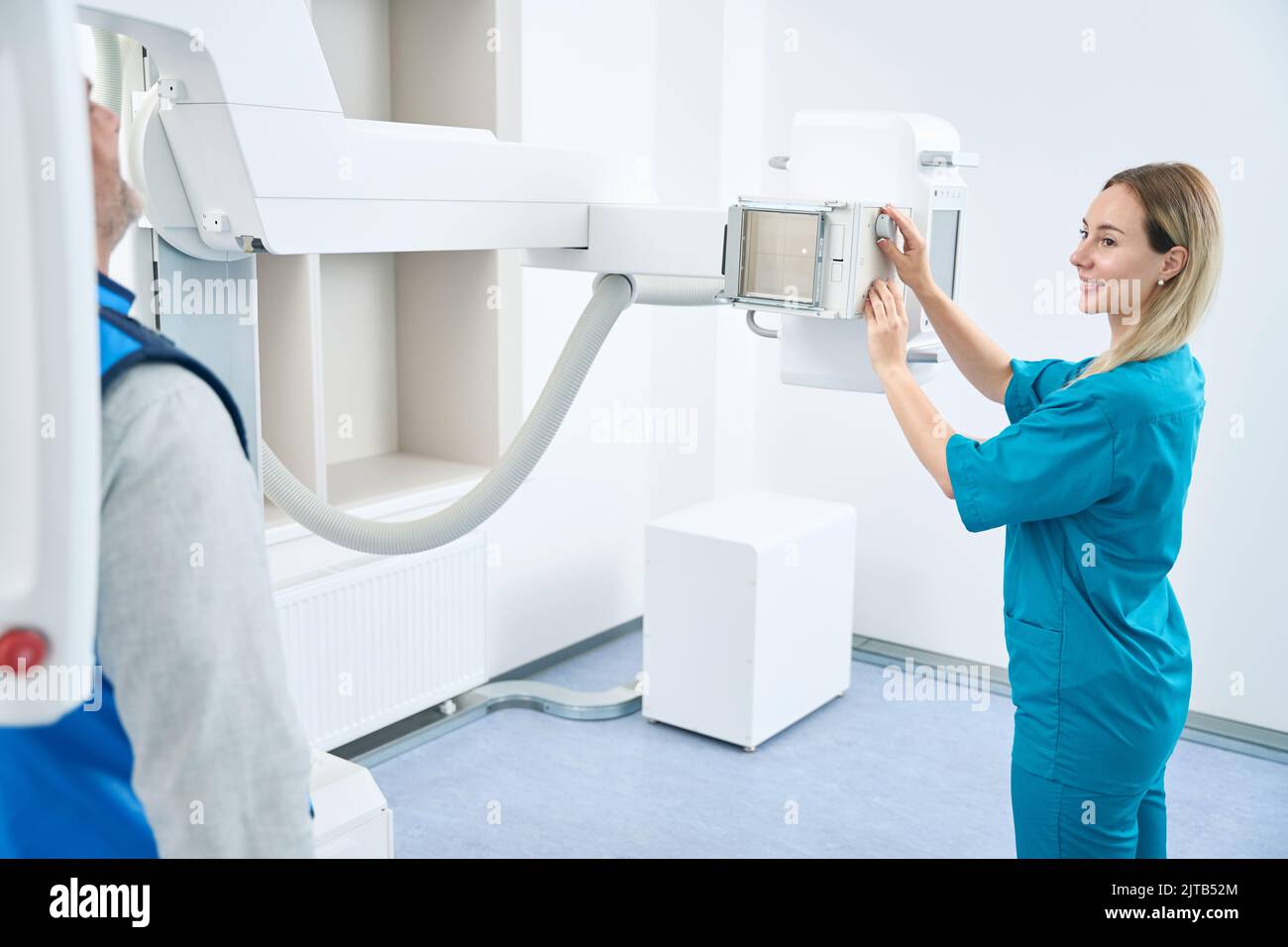 Woman doctor prepares patient for x-ray of head on machine Stock Photo ...