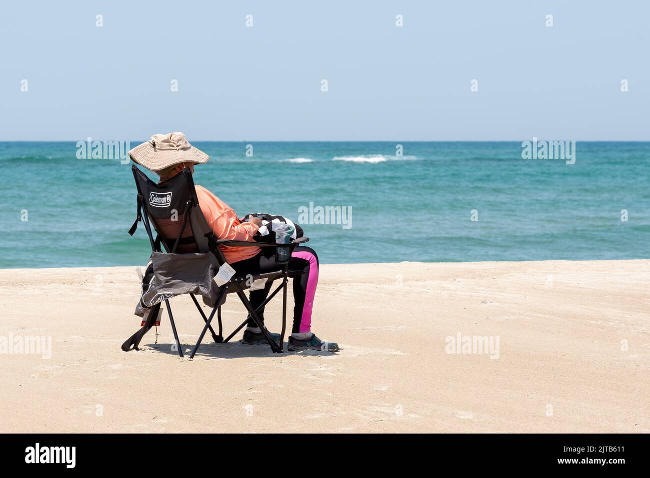 A person resting on a chair at a sandy beach in Crystal Coast, North ...