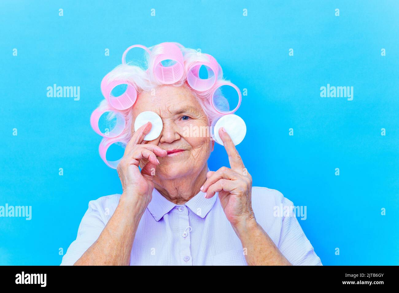 lady removing makeup from her face with cotton pad and smiling at ...