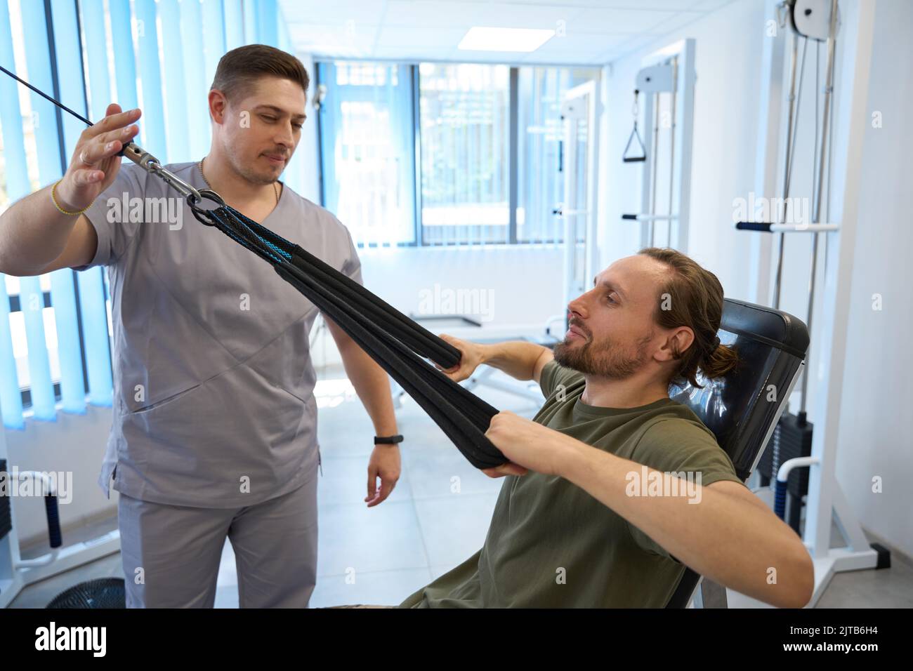 Instructor in the rehabilitation center conducts a physiotherapy ...