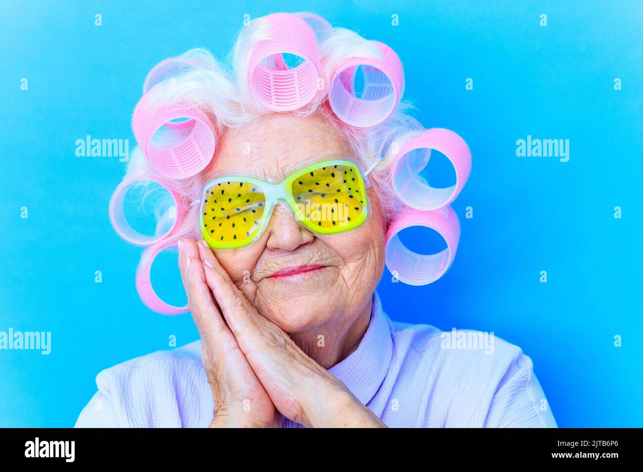 cute 80 years old woman with curlers on white hair wear hyaluronic acid ...