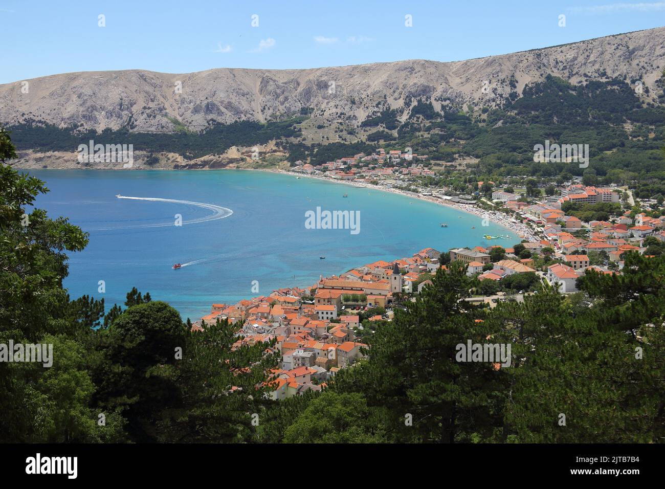 A tall city building near the sea with a cloudy blue sky above Stock ...
