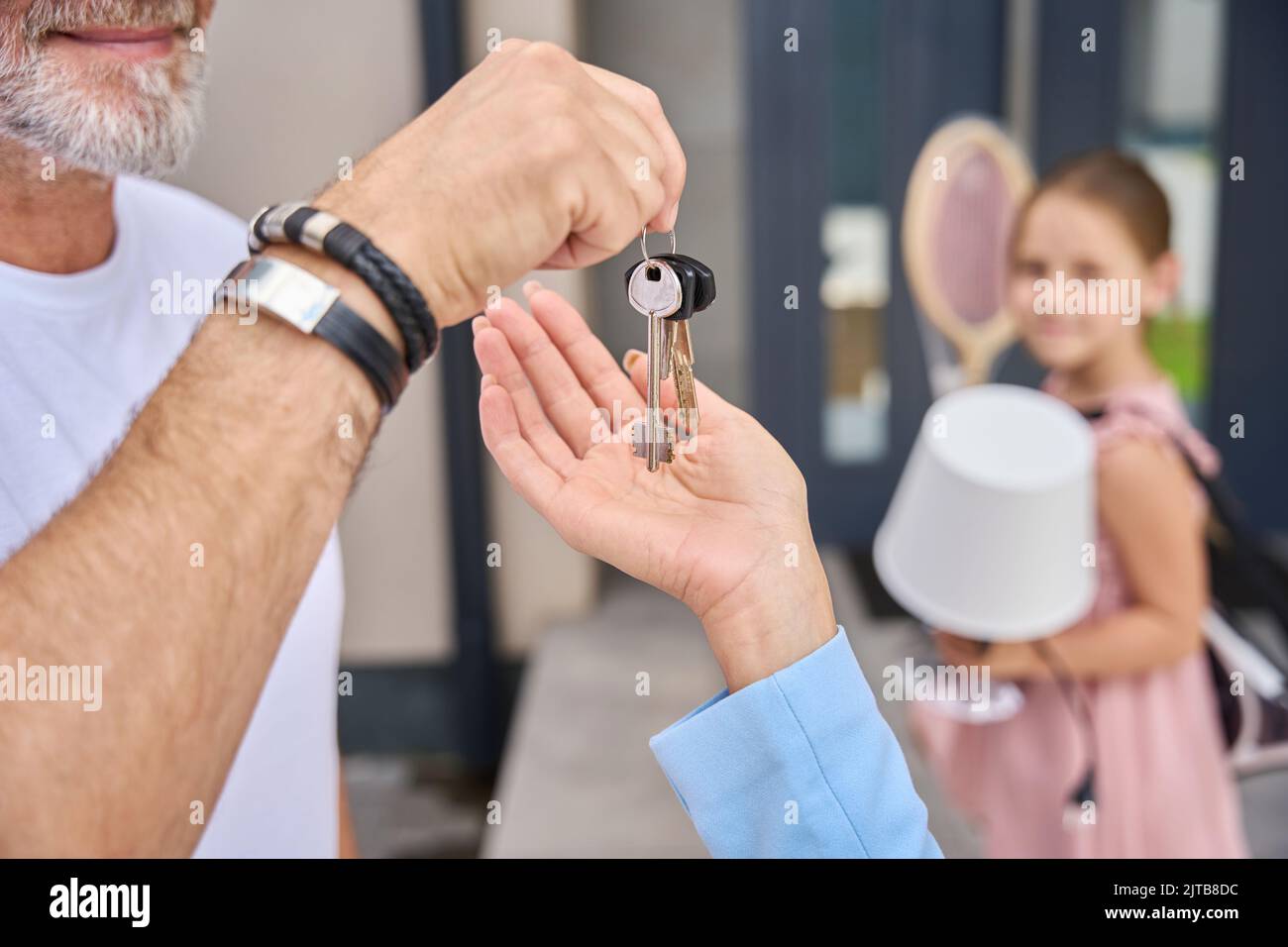 Man hand passes keys from new home to woman hand Stock Photo - Alamy