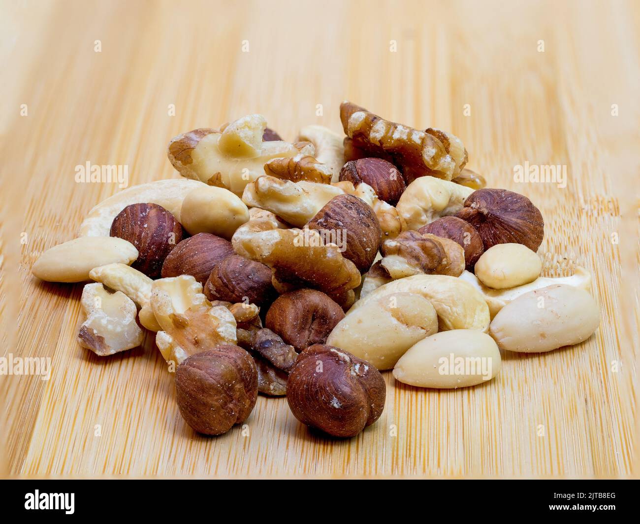 macro view mixed nuts isolated on a sustainable bamboo background Stock ...