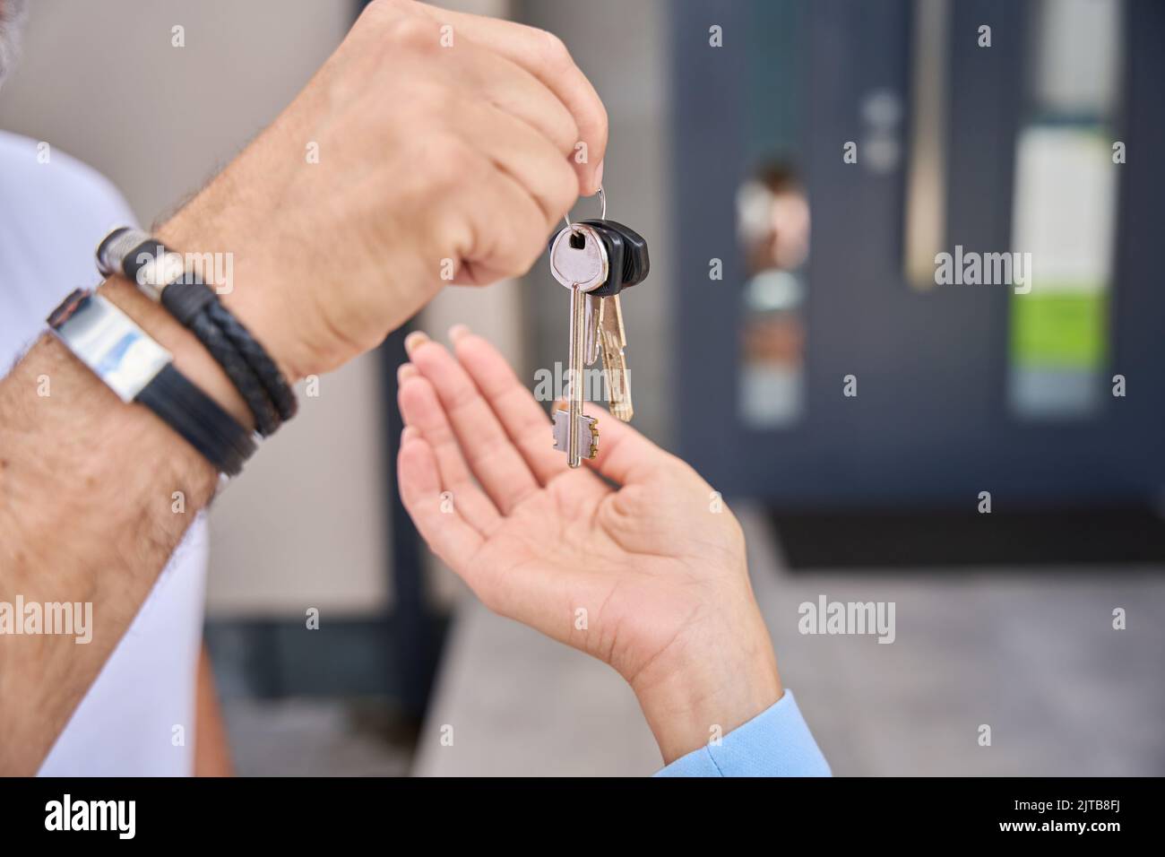 Close-up of man's hand, giving woman hand keys from house Stock Photo ...