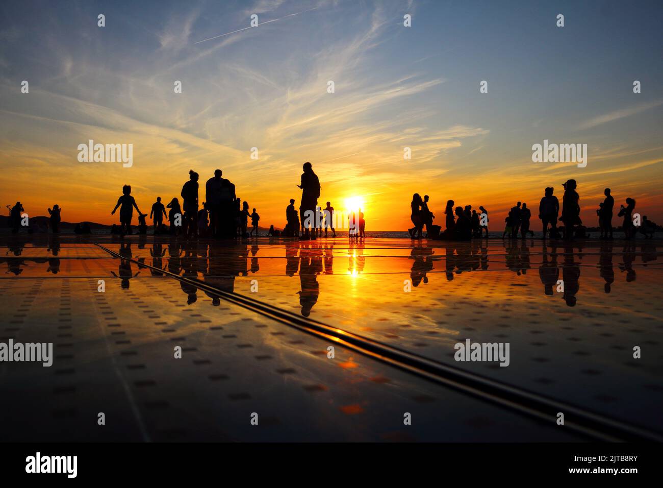A mesmerizing view of the golden sunset over the park while people are ...