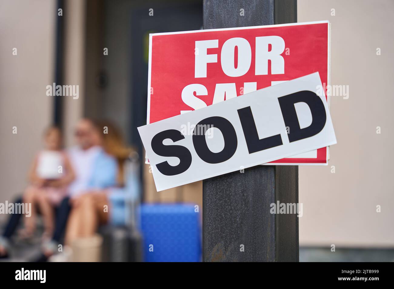 Close up sign for sale. Family sitting on steps Stock Photo - Alamy