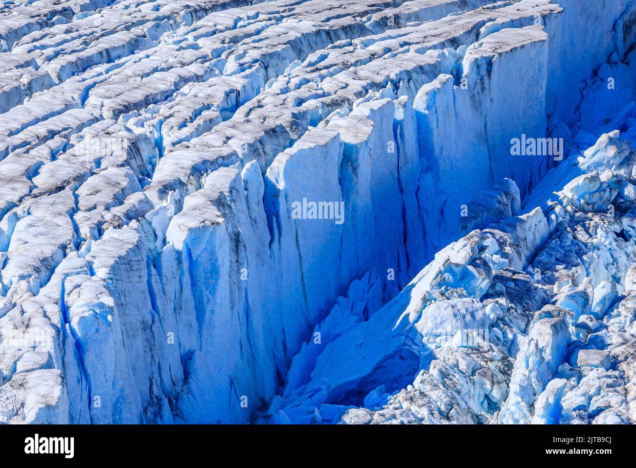A wall of blue ice exposed along the face of a glacier Stock Photo - Alamy