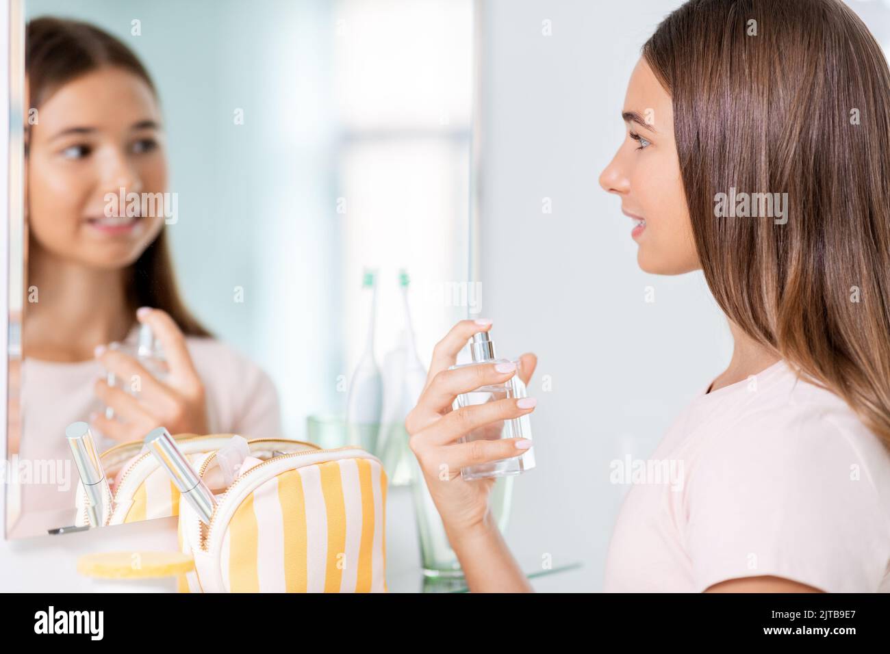 teenage girl spraying perfume at bathroom Stock Photo - Alamy