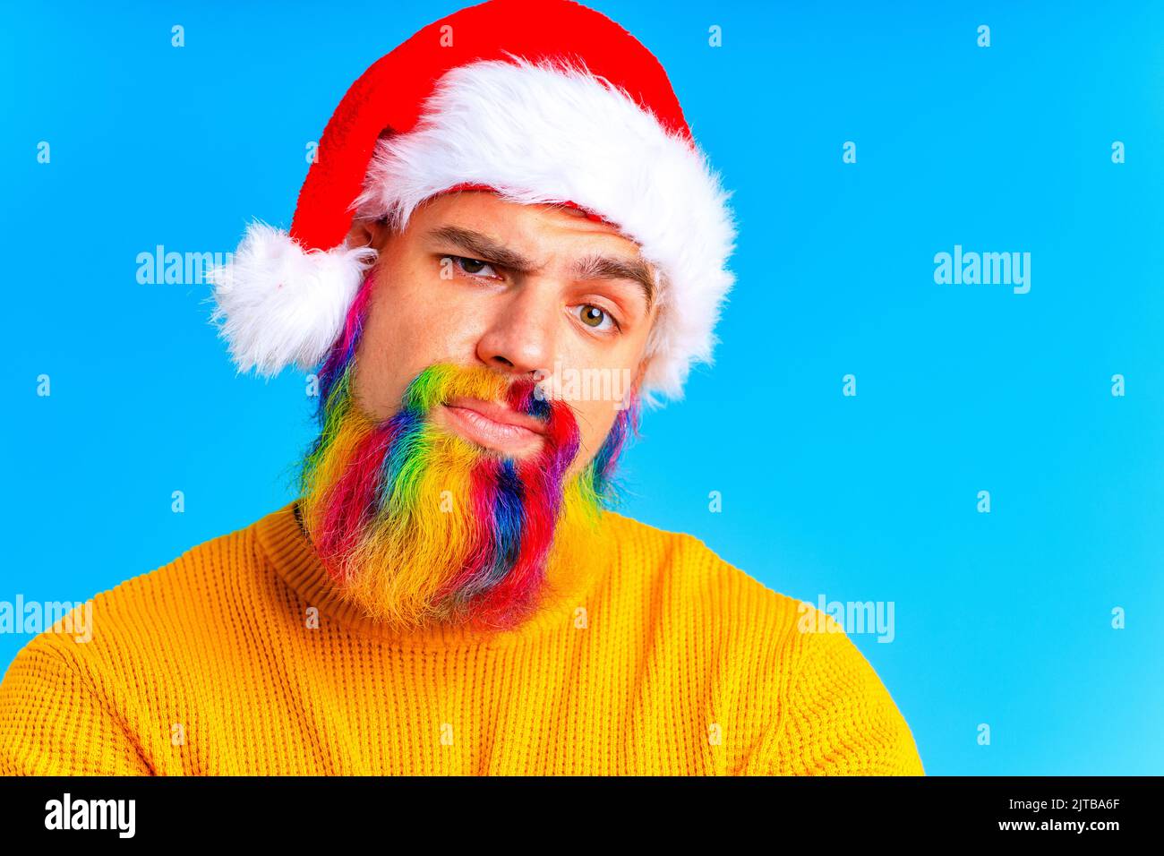 man with colored rainbow beard in the red Santa Claus costume in blue ...