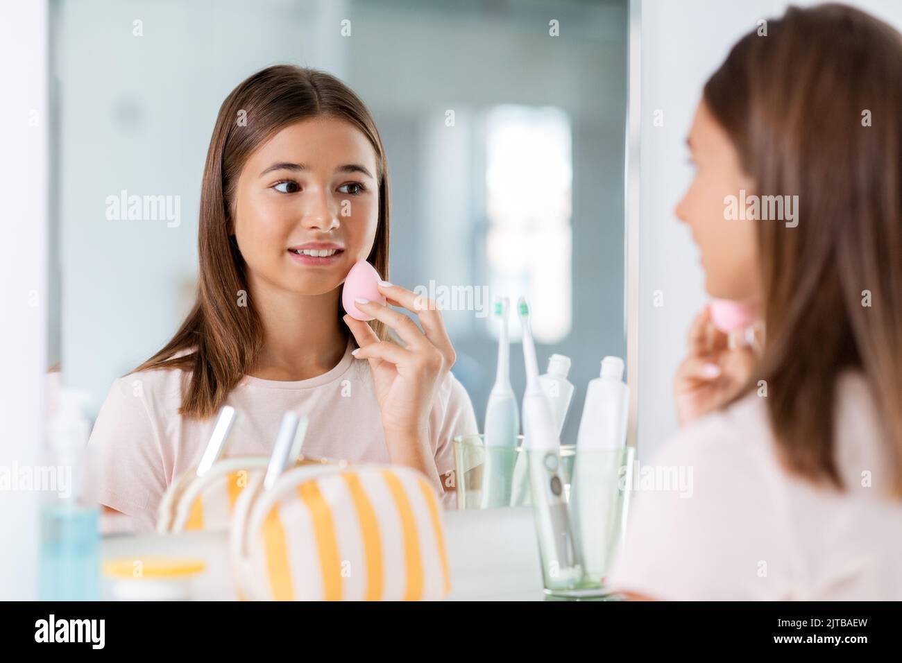 teenage girl applying foundation to face Stock Photo - Alamy