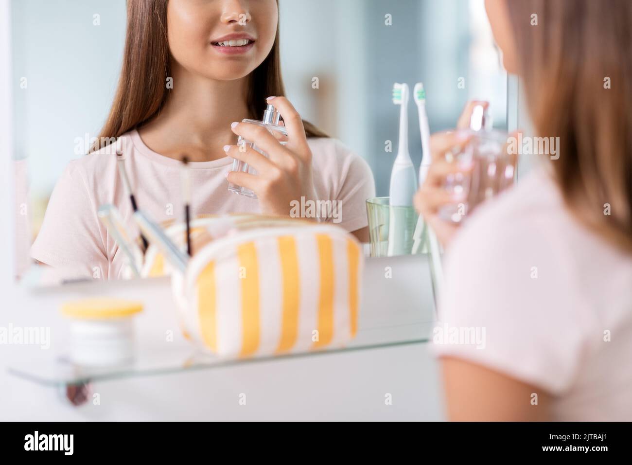 teenage girl spraying perfume at bathroom Stock Photo - Alamy